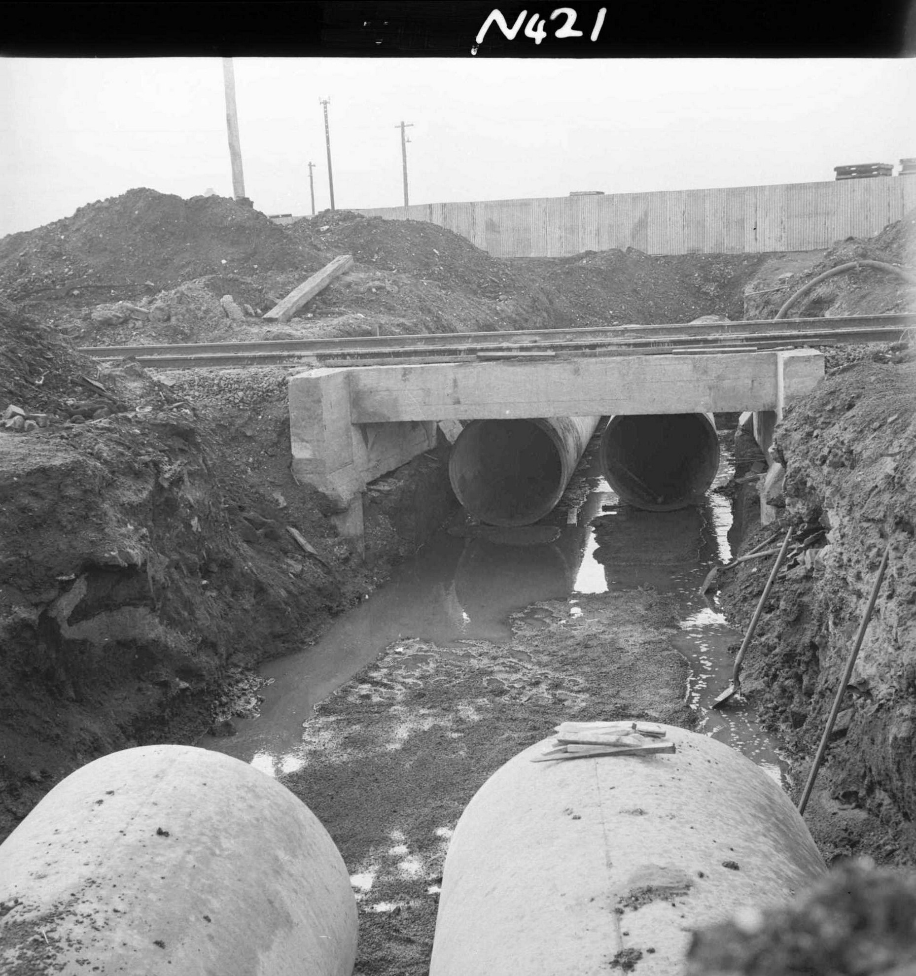 N421 Image showing a low-angle view of pipes passing under the railway ...