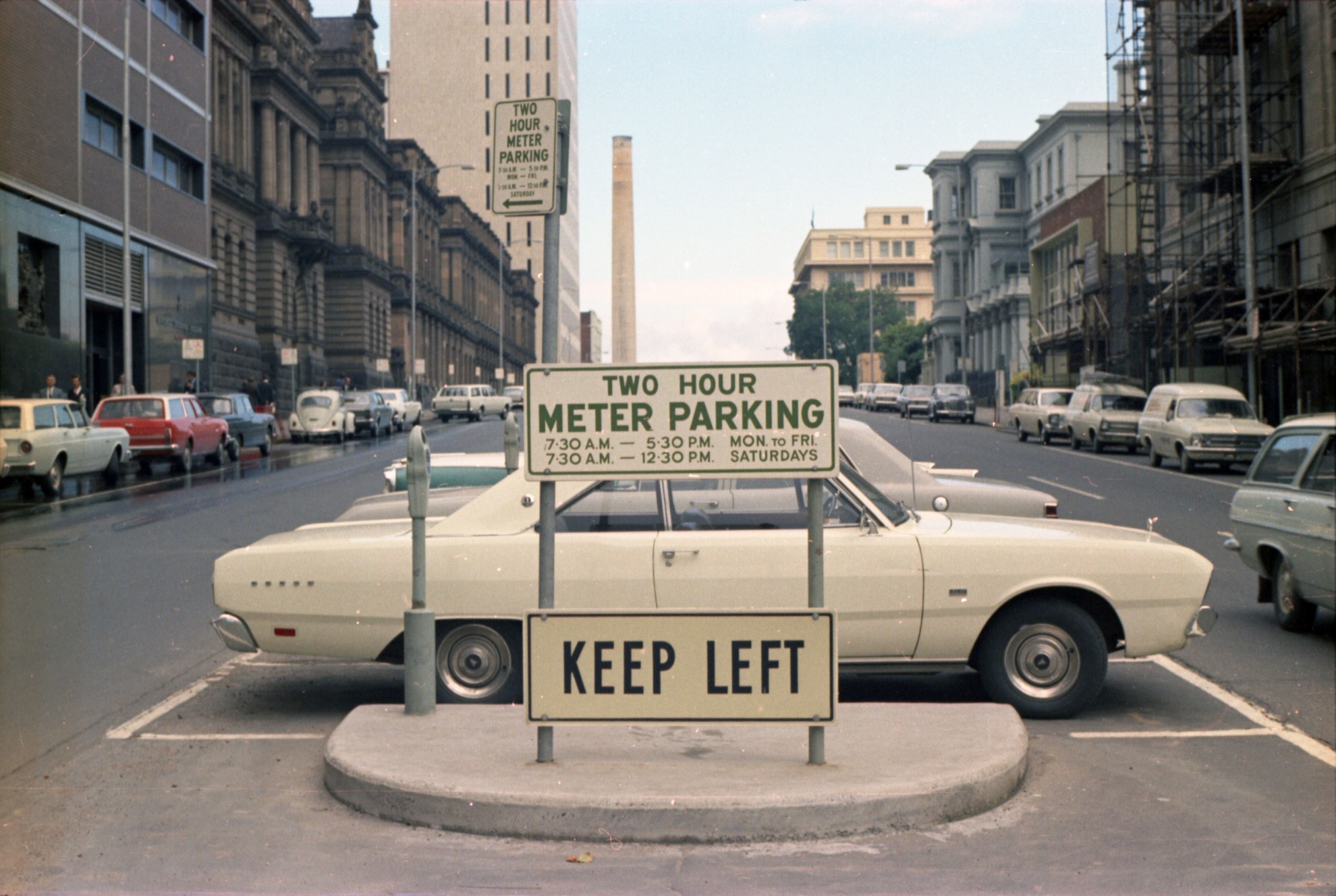 35B-12a Image of parking and "keep left" signs in front of parked cars ...
